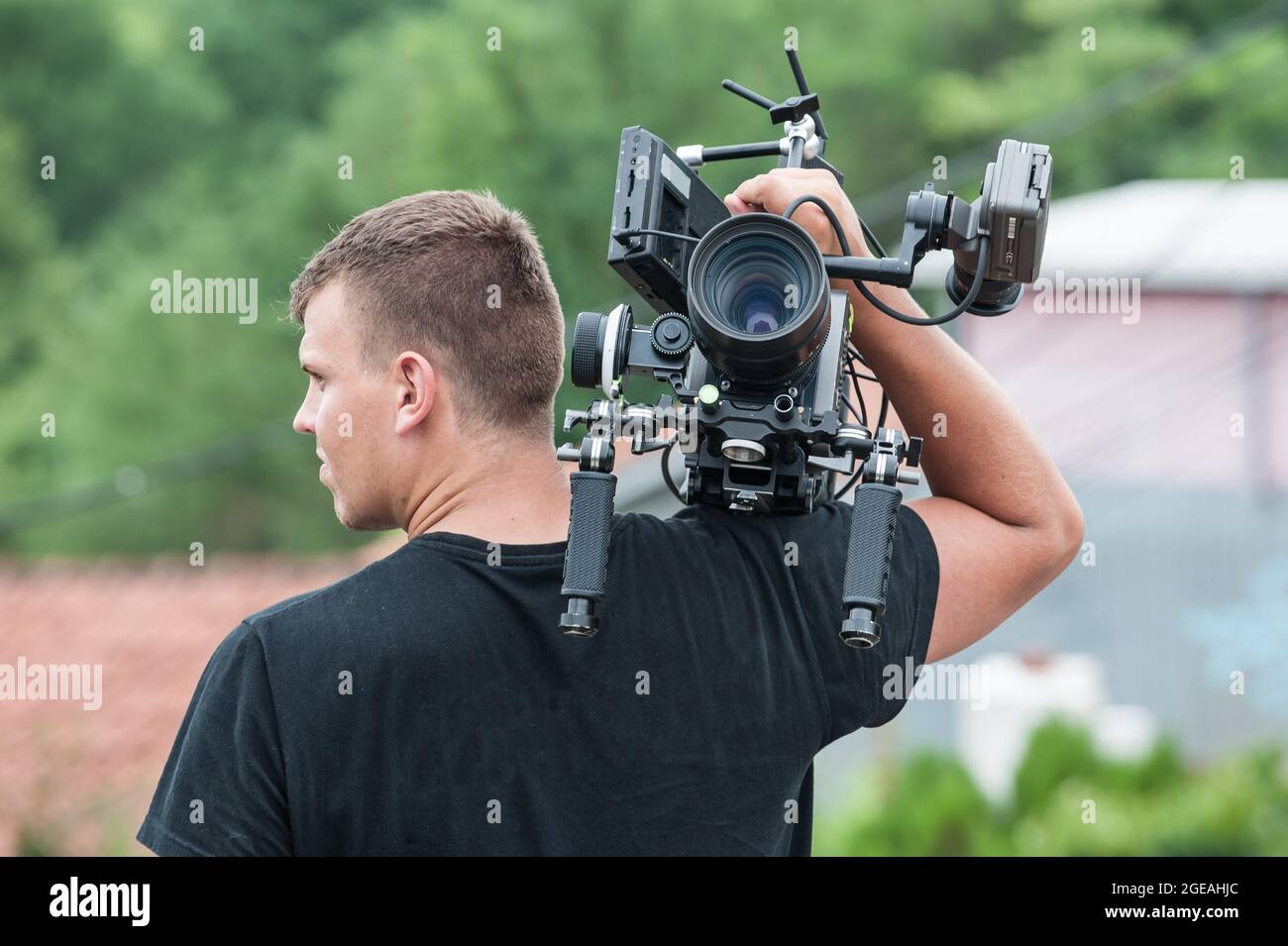 Behind the scene. Cameraman with his camera on outdoor set ...
