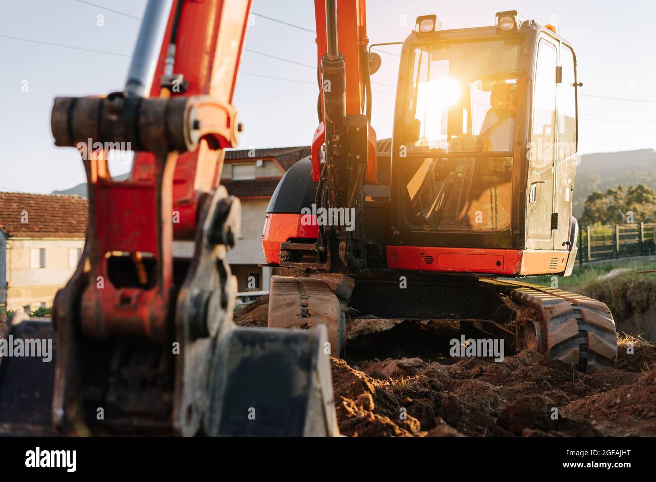 Backhoe excavator on a construction site at sunset Stock Photo - Alamy