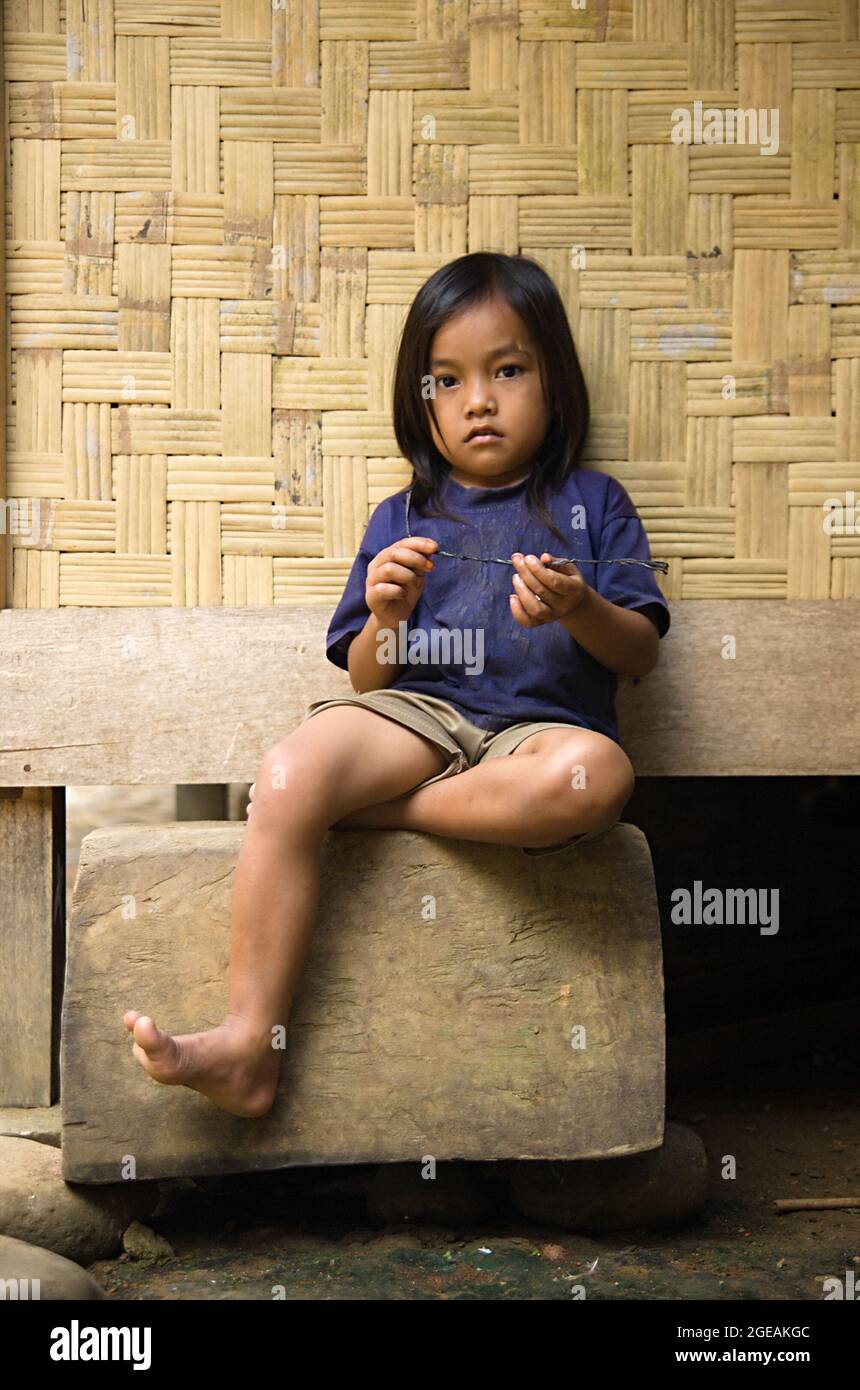 A cute Baduy girl sits beside her house. Baduy is a tribe in Banten ...