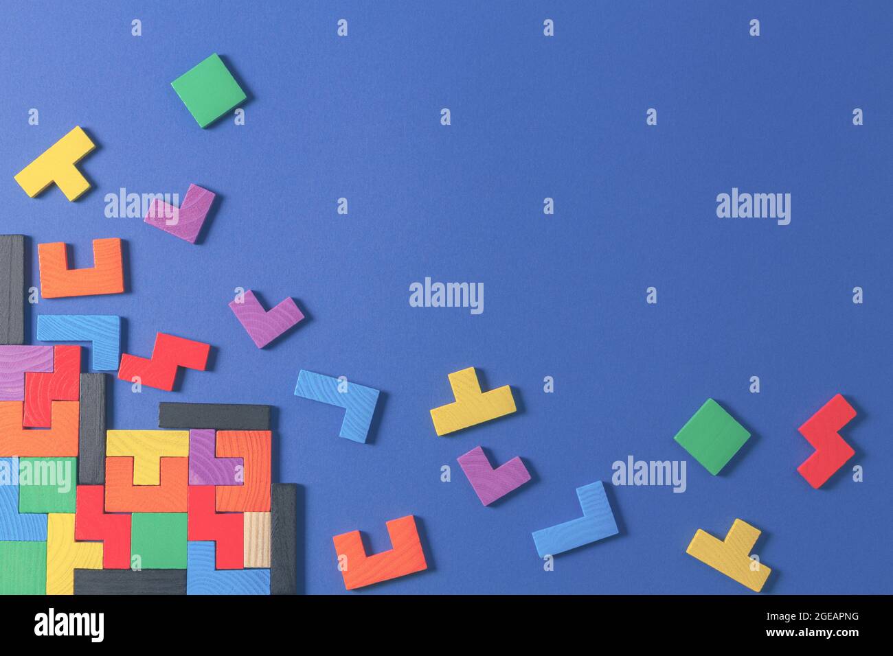 Different colorful shapes wooden puzzle blocks on blue background ...