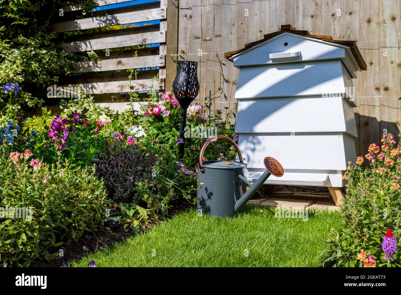 Cottage style garden with beehive and garden lights Stock Photo - Alamy
