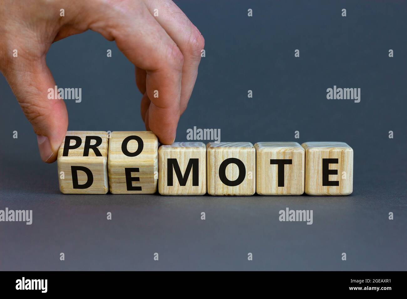 Promote or demote symbol. Businessman turns cubes and changes the word ...