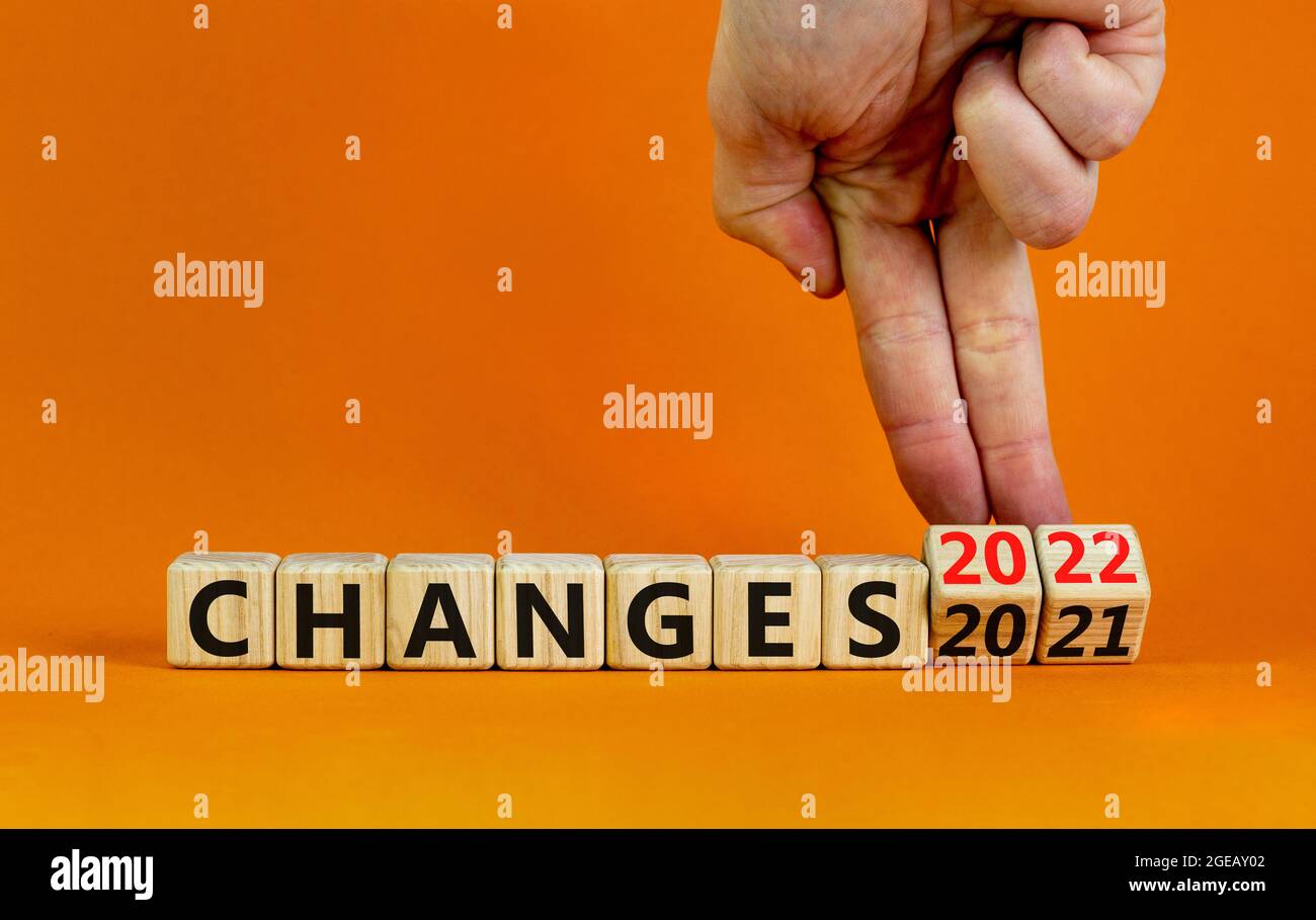 Planning 2022 changes new year symbol. Businessman turns a wooden cube ...