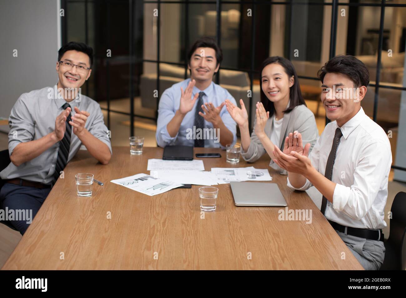 Chinese business people clapping hands in meeting room Stock Photo - Alamy