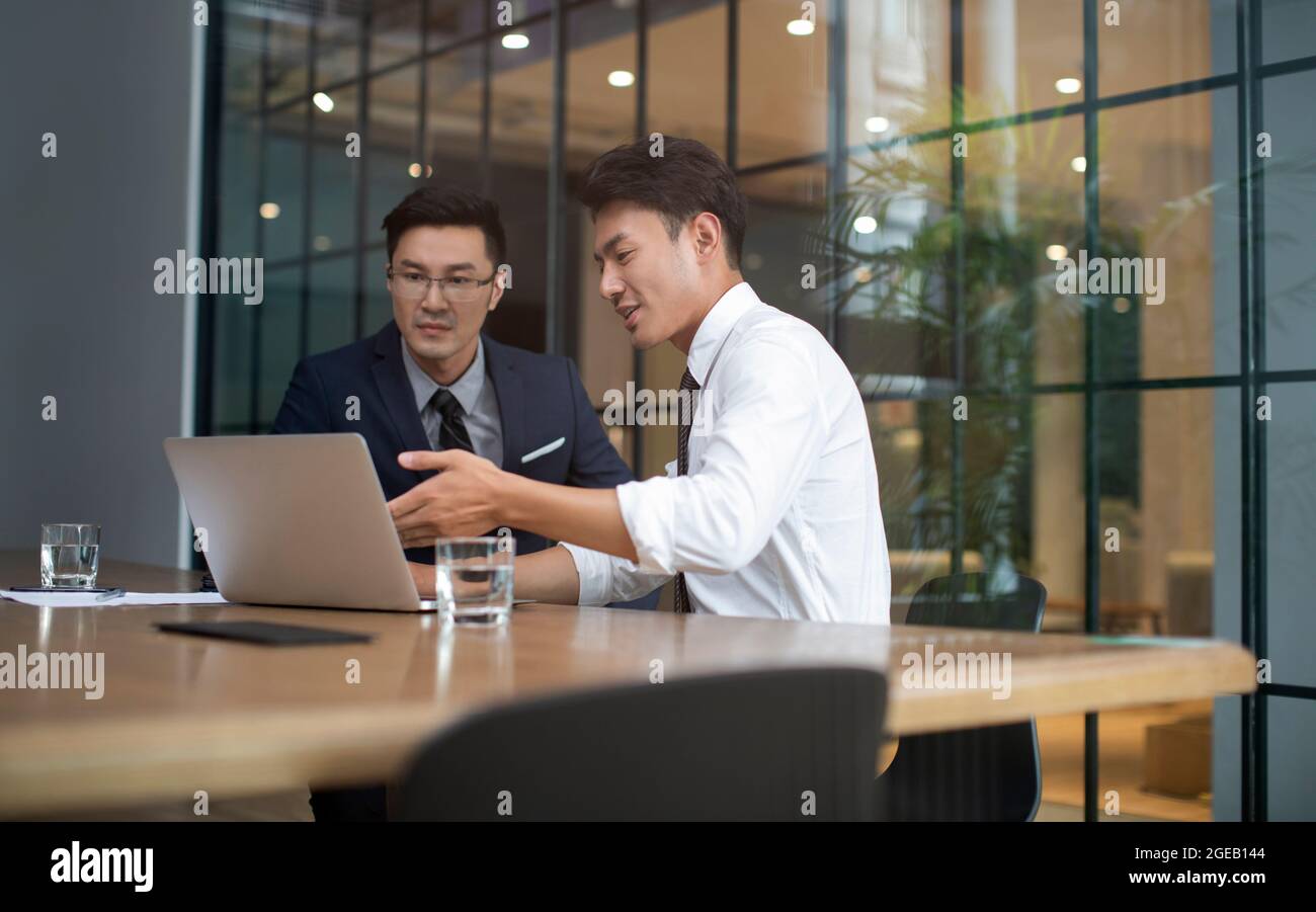 Successful Chinese businessmen talking in office Stock Photo - Alamy