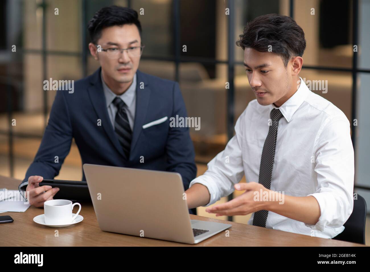 Successful Chinese businessmen talking in office Stock Photo - Alamy