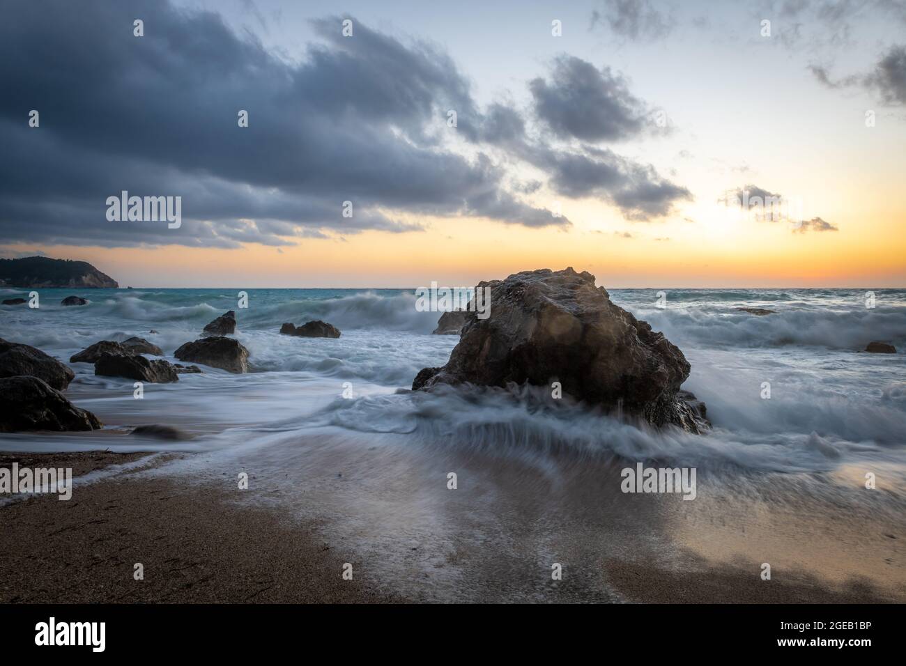 A beach sunset with the wave receding on the beach Stock Photo - Alamy