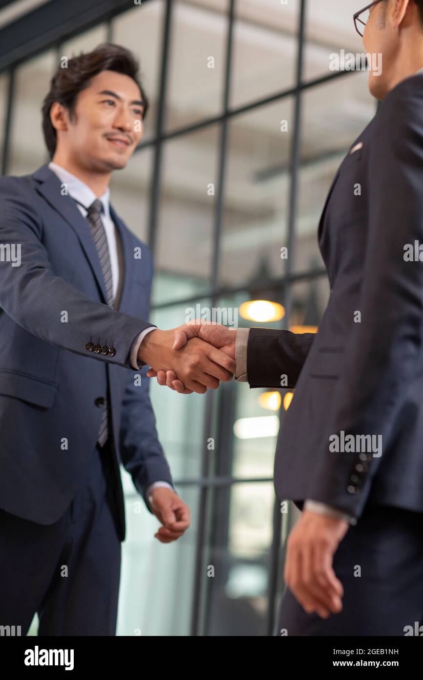 Standing shaking hands looking away authority communication smiling hi ...