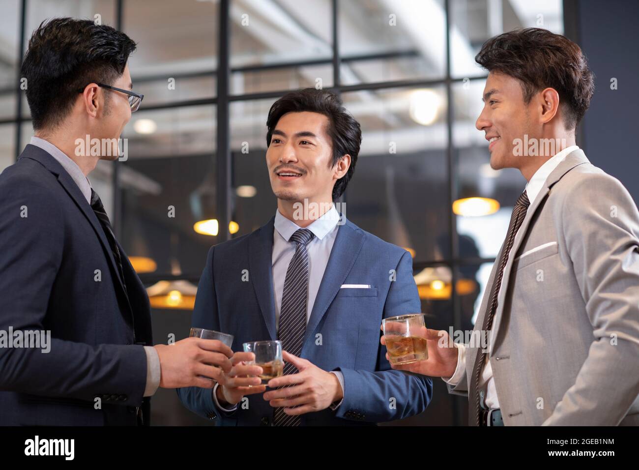 Successful Chinese businessmen drinking alcohol in office Stock Photo ...