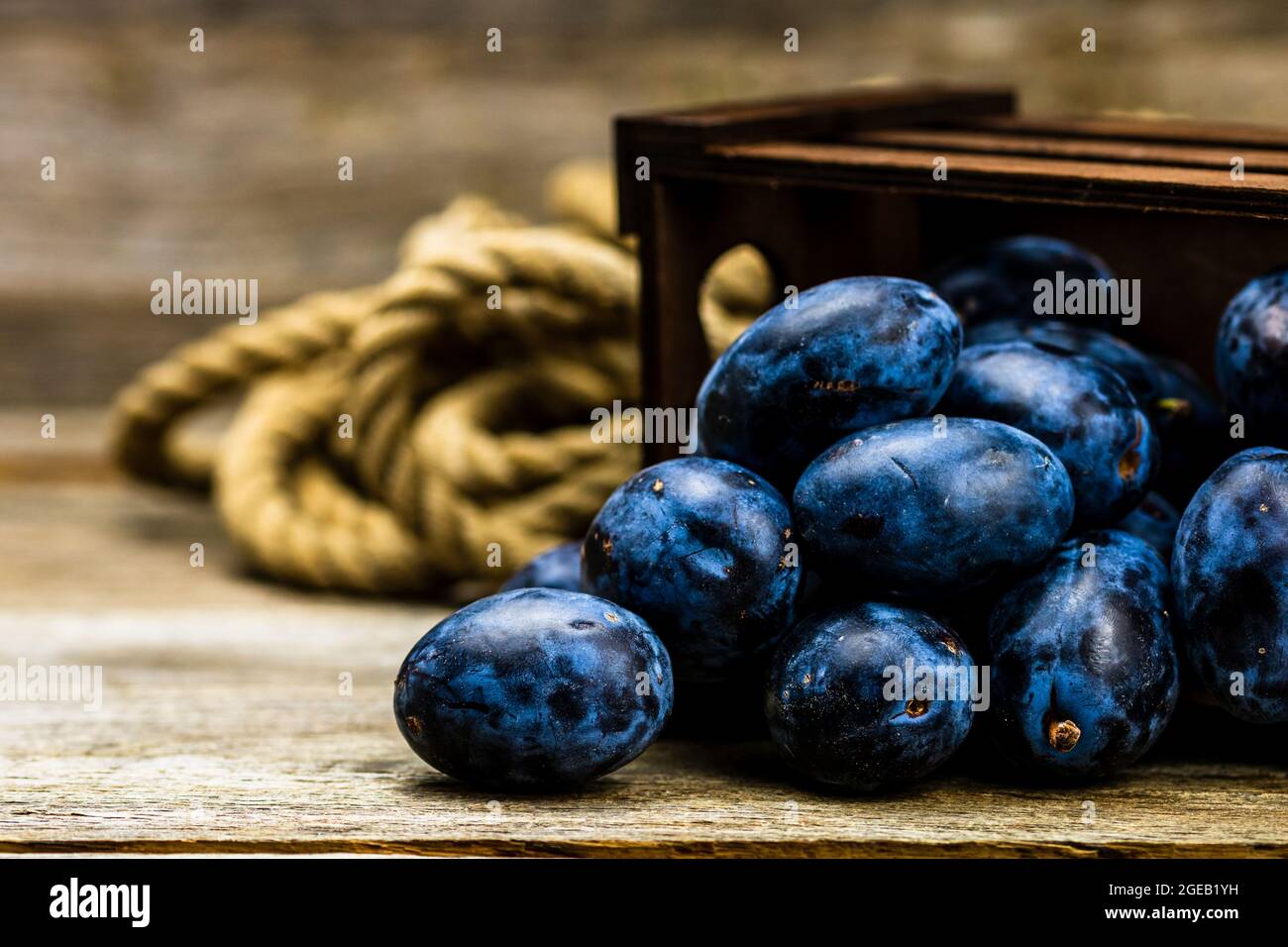 Ripe blue plums in a wooden crate in a rustic composition Stock Photo ...