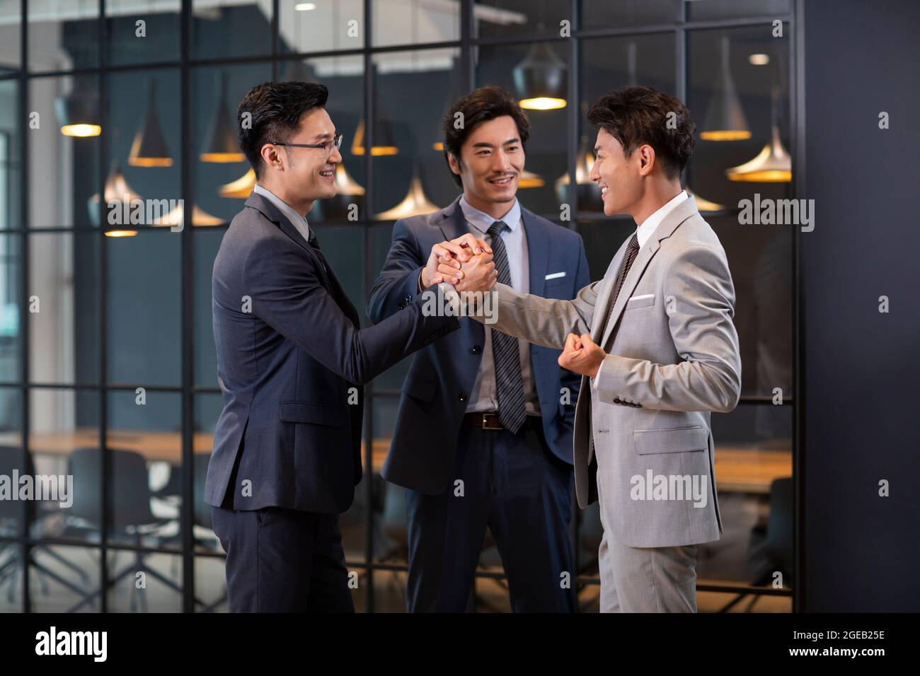 Successful Chinese businessmen celebrating in office Stock Photo - Alamy