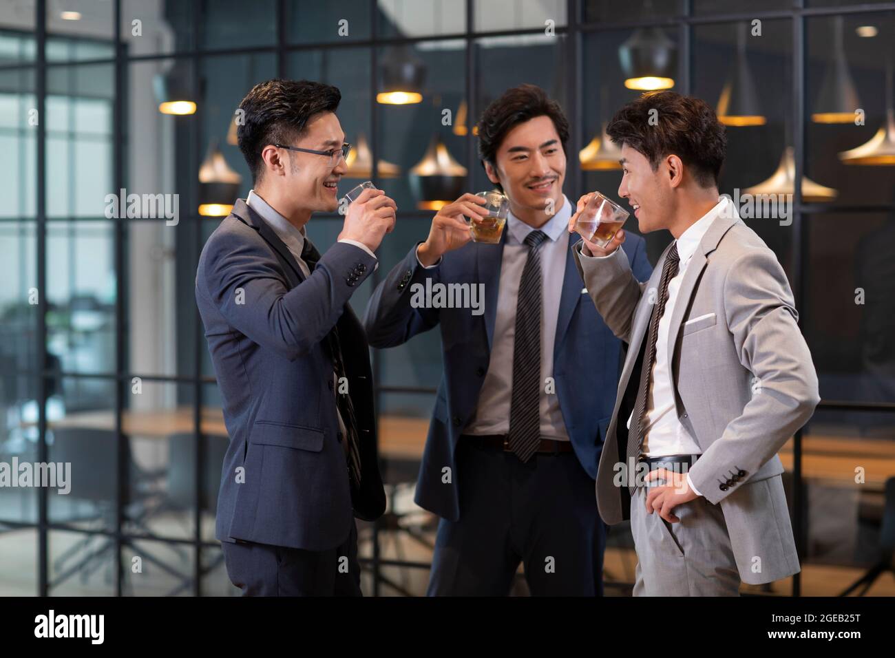 Successful Chinese businessmen drinking alcohol in office Stock Photo ...