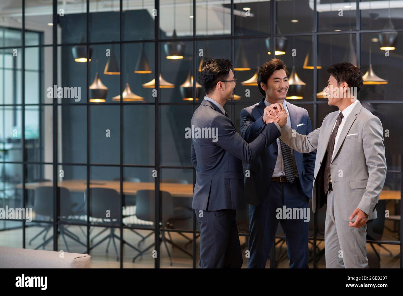 Successful Chinese businessmen celebrating in office Stock Photo - Alamy