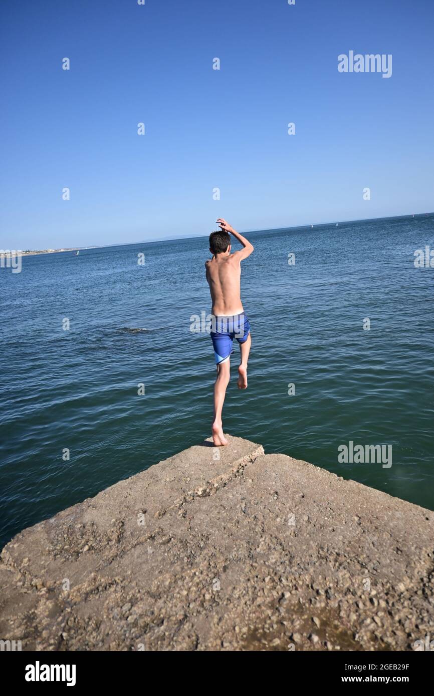Boy jumping into the ocean hi-res stock photography and images - Alamy