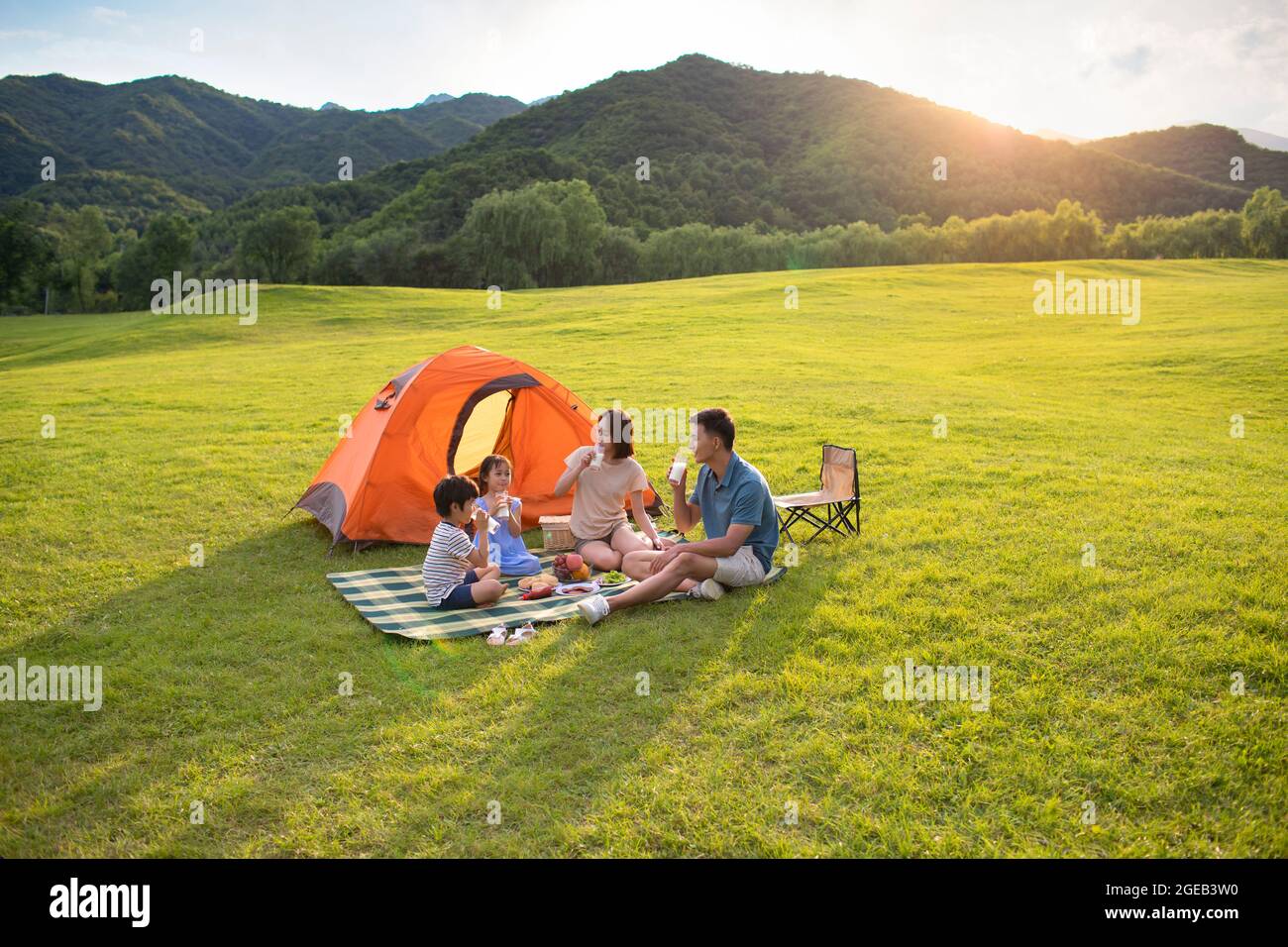 Happy young Chinese family having a picnic outdoors Stock Photo - Alamy