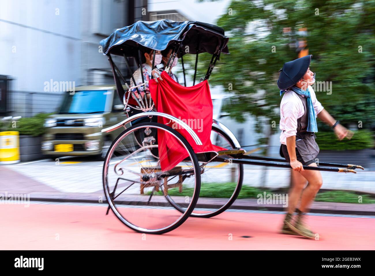 A pulled rickshaw or jinrikisha transports tourists around the Sensoji ...