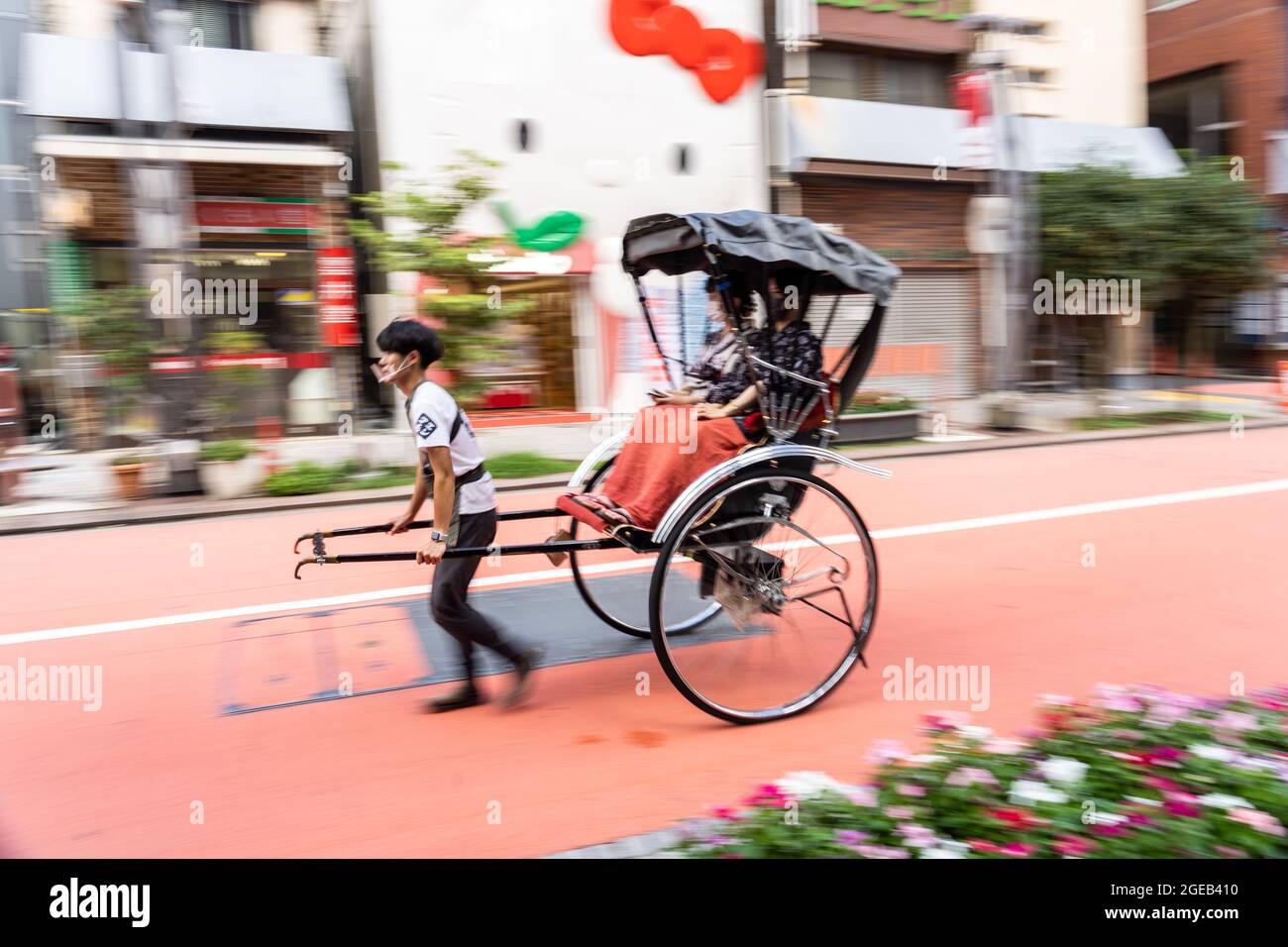 A pulled rickshaw or jinrikisha transports tourists around the Sensoji ...