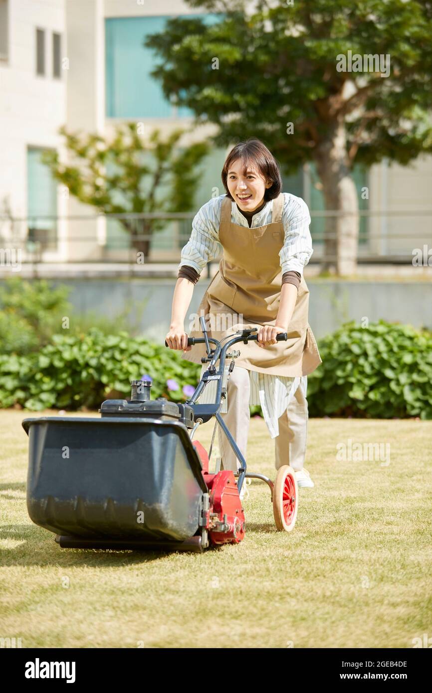 Woman pushing lawn mower hi-res stock photography and images - Alamy