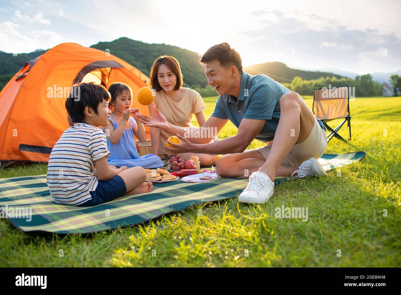 Happy young Chinese family having a picnic outdoors Stock Photo - Alamy