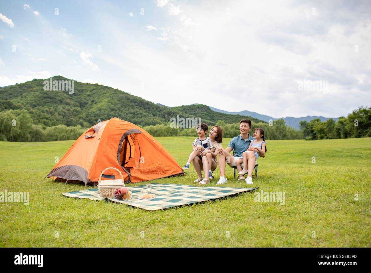 Happy young Chinese family camping outdoors Stock Photo - Alamy