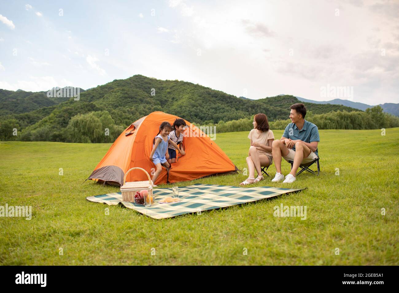Happy young Chinese family camping outdoors Stock Photo - Alamy