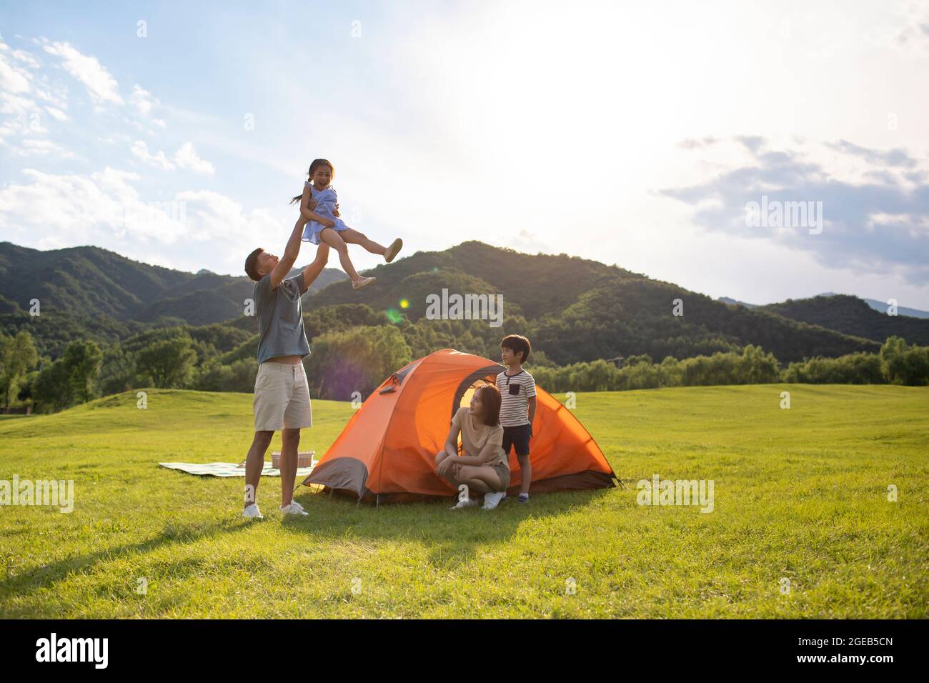Happy young Chinese family camping outdoors Stock Photo - Alamy