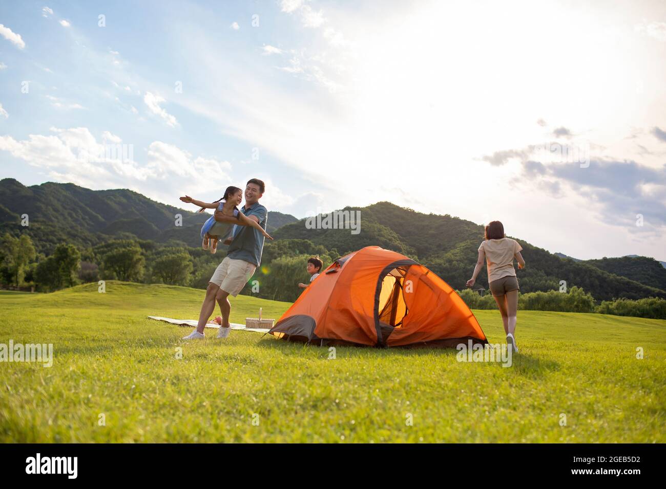 Happy young Chinese family camping outdoors Stock Photo - Alamy
