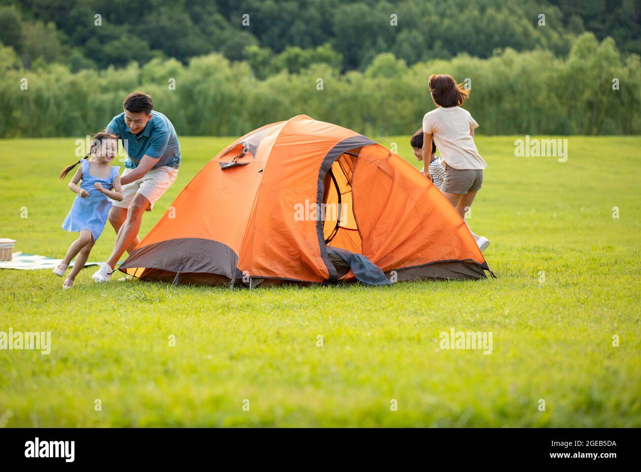 Happy young Chinese family camping outdoors Stock Photo - Alamy