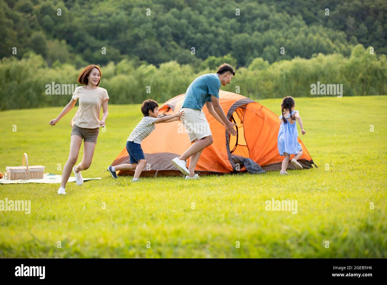 Happy young Chinese family camping outdoors Stock Photo - Alamy