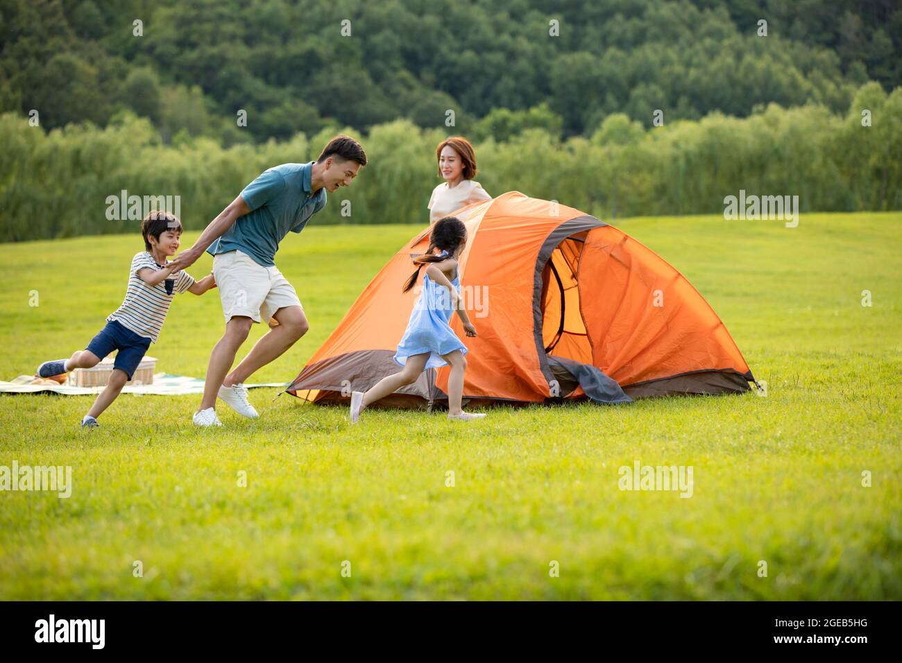 Happy young Chinese family camping outdoors Stock Photo - Alamy