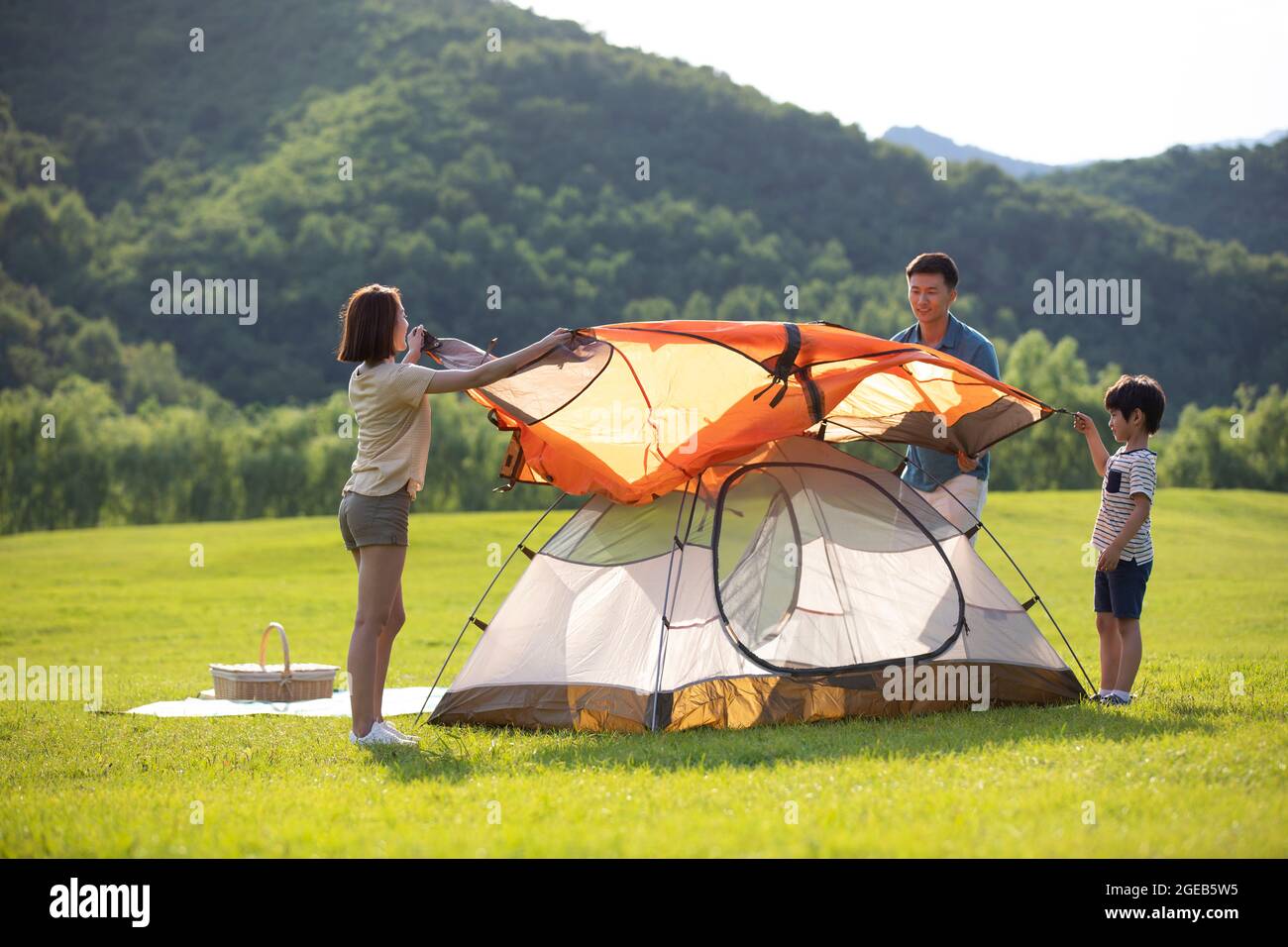 Happy young Chinese family camping outdoors Stock Photo - Alamy
