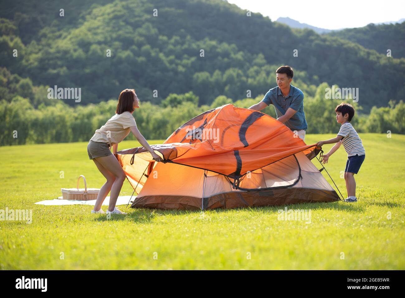 Happy young Chinese family camping outdoors Stock Photo - Alamy