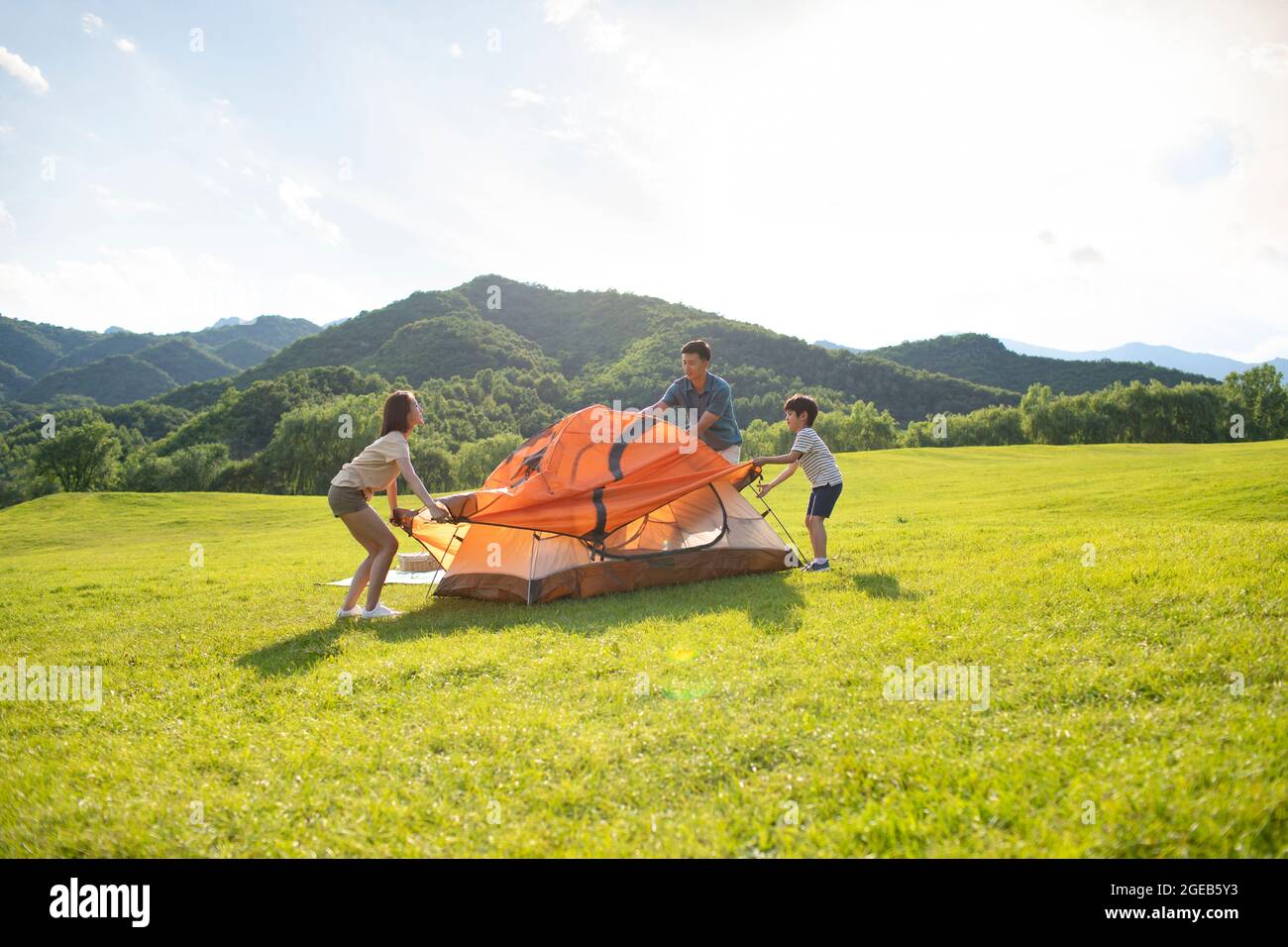 Happy young Chinese family camping outdoors Stock Photo - Alamy