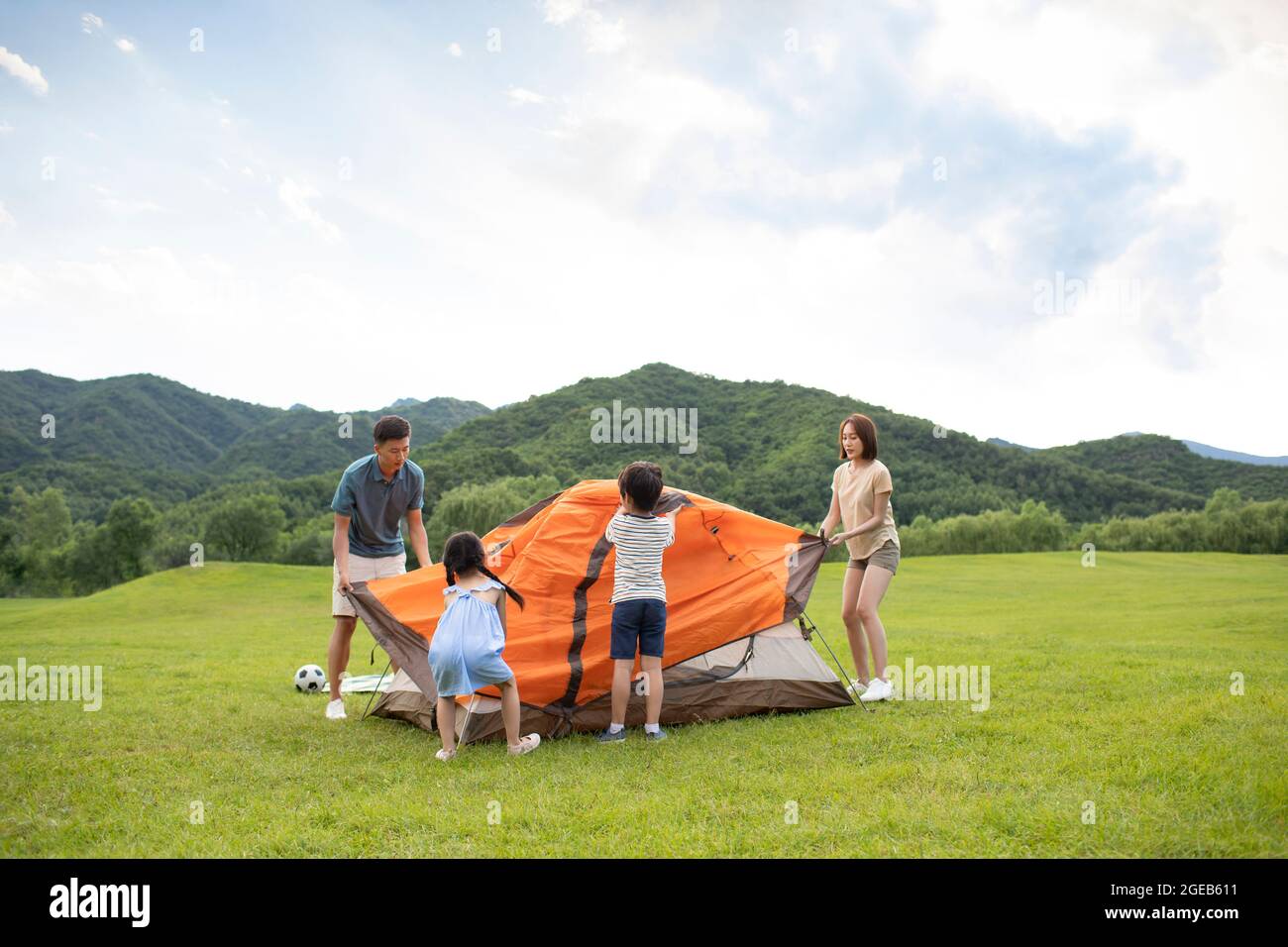 Happy young Chinese family camping outdoors Stock Photo - Alamy