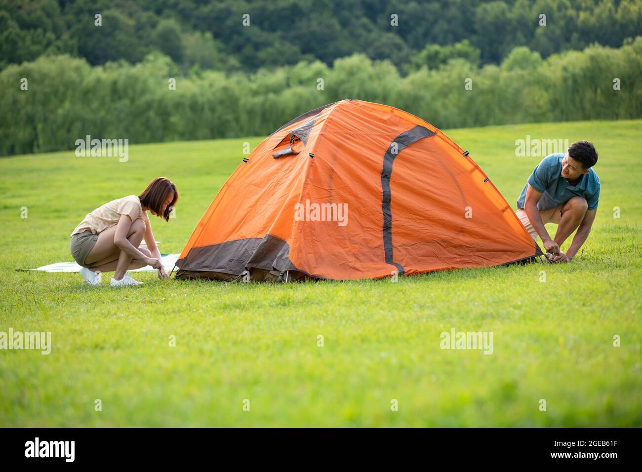 Happy young Chinese couple camping outdoors Stock Photo - Alamy
