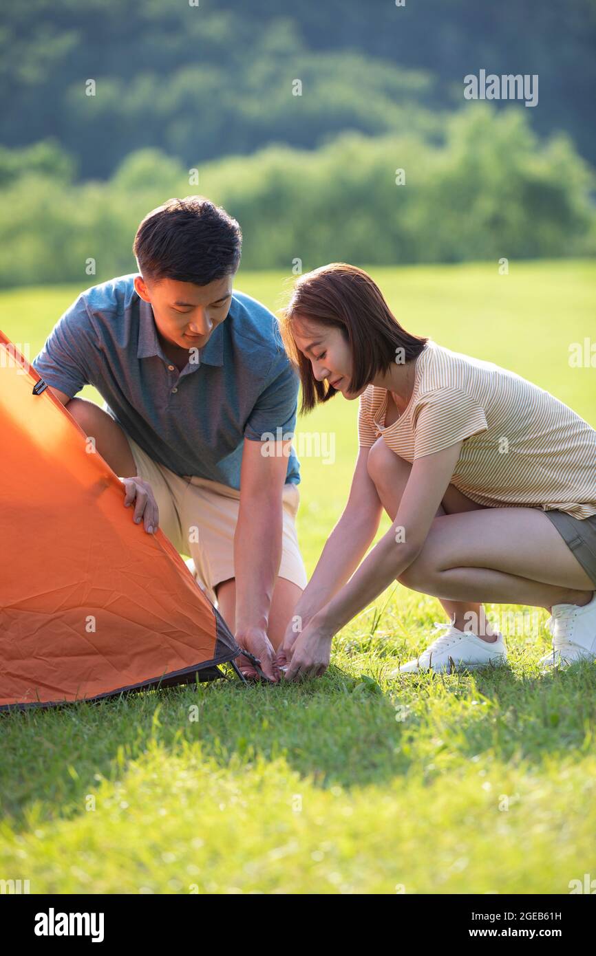 Happy young Chinese couple camping outdoors Stock Photo - Alamy