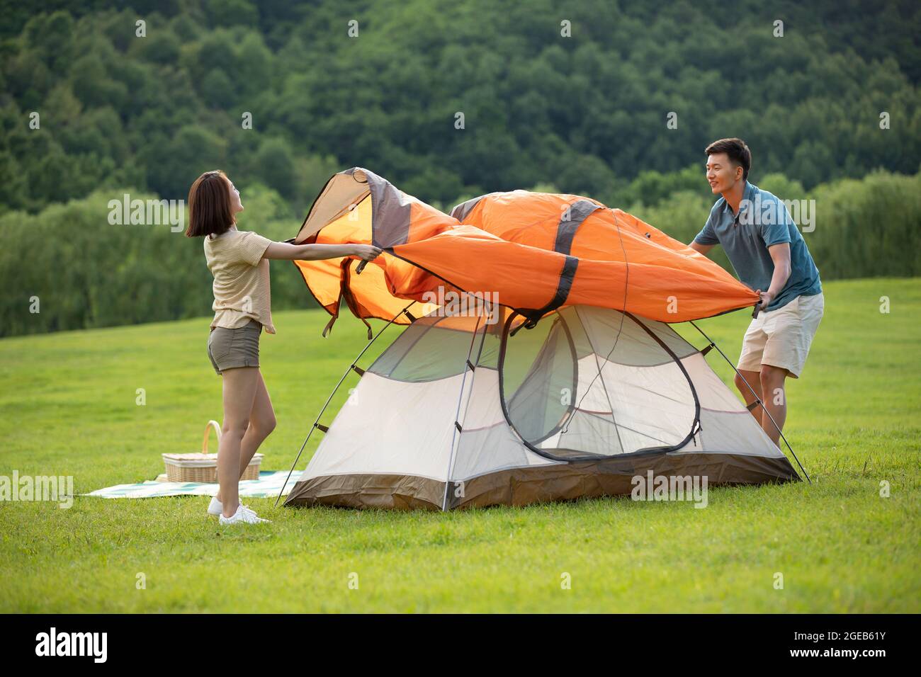 Happy young Chinese couple camping outdoors Stock Photo - Alamy