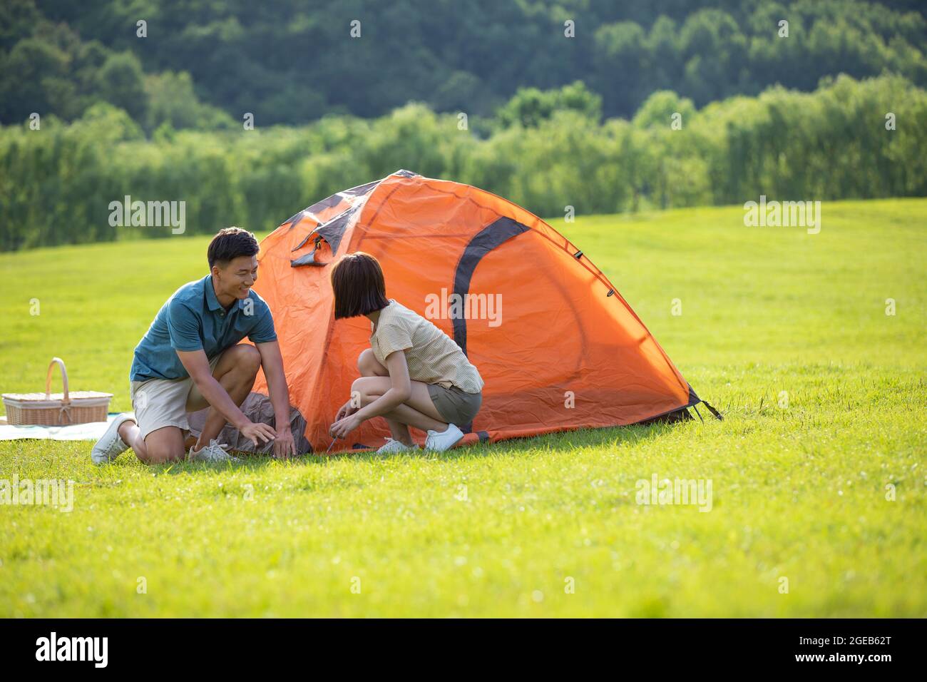 Happy young Chinese couple camping outdoors Stock Photo - Alamy