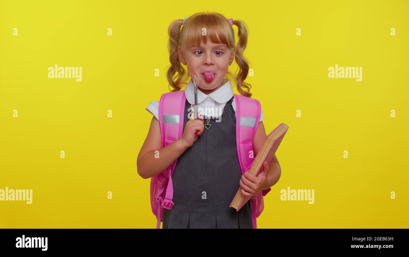 Joyful funny schoolgirl making humorous face with eyes crossed, playing ...