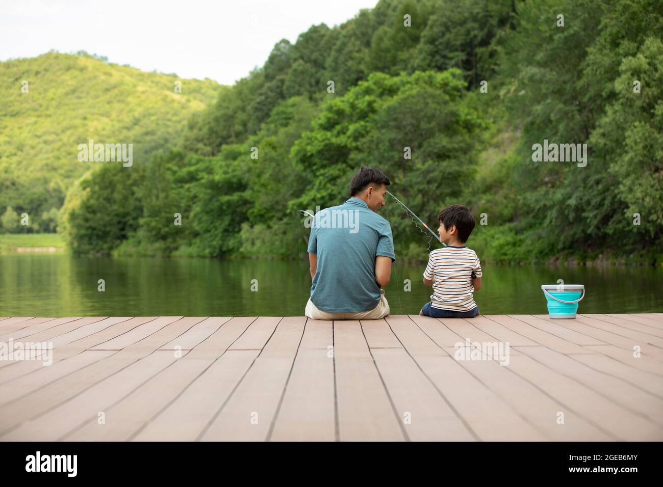 Happy Chinese father and son fishing by the river Stock Photo - Alamy