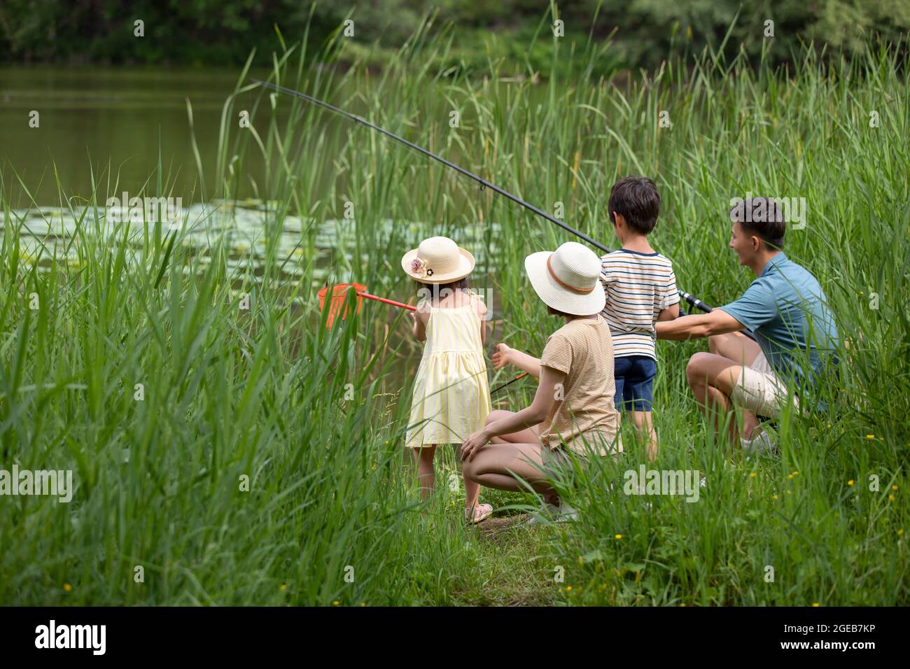 Happy young Chinese family fishing by the river Stock Photo - Alamy
