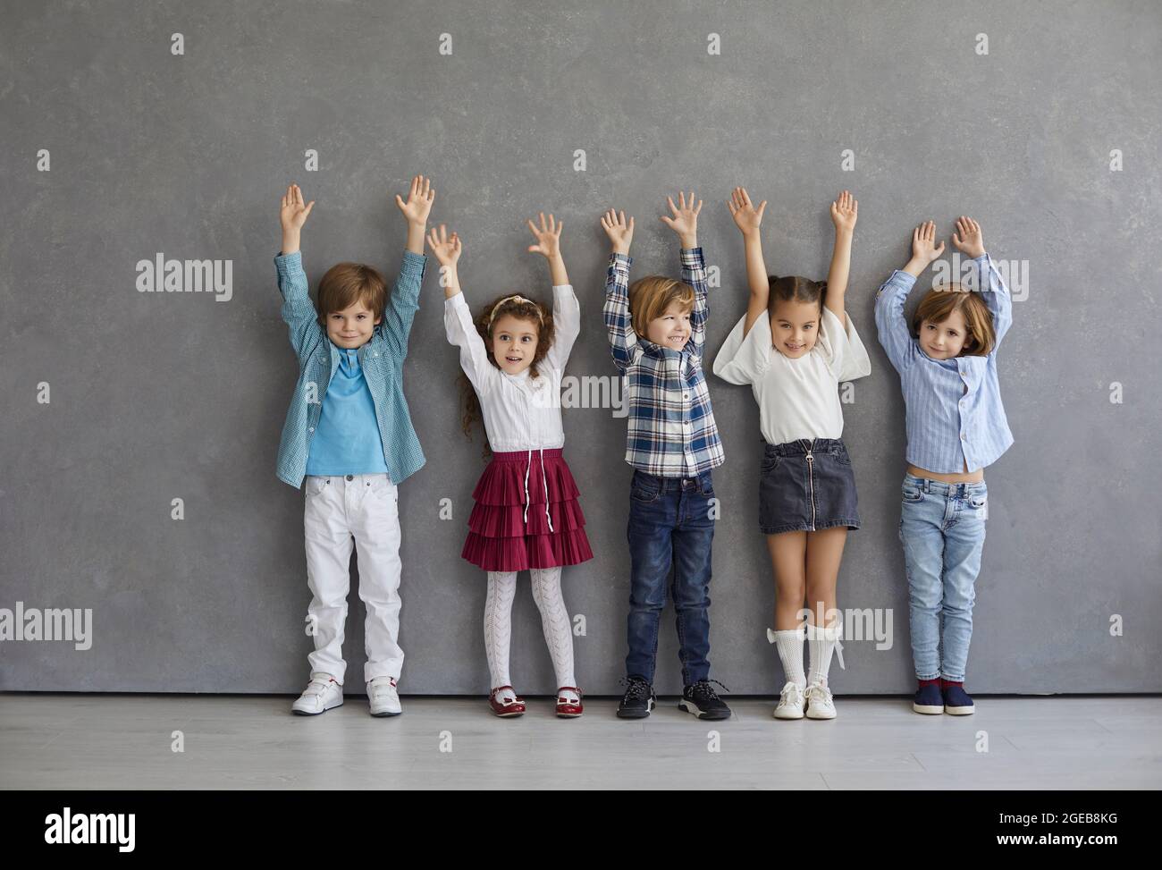 Studio group portrait of happy little children standing together and ...