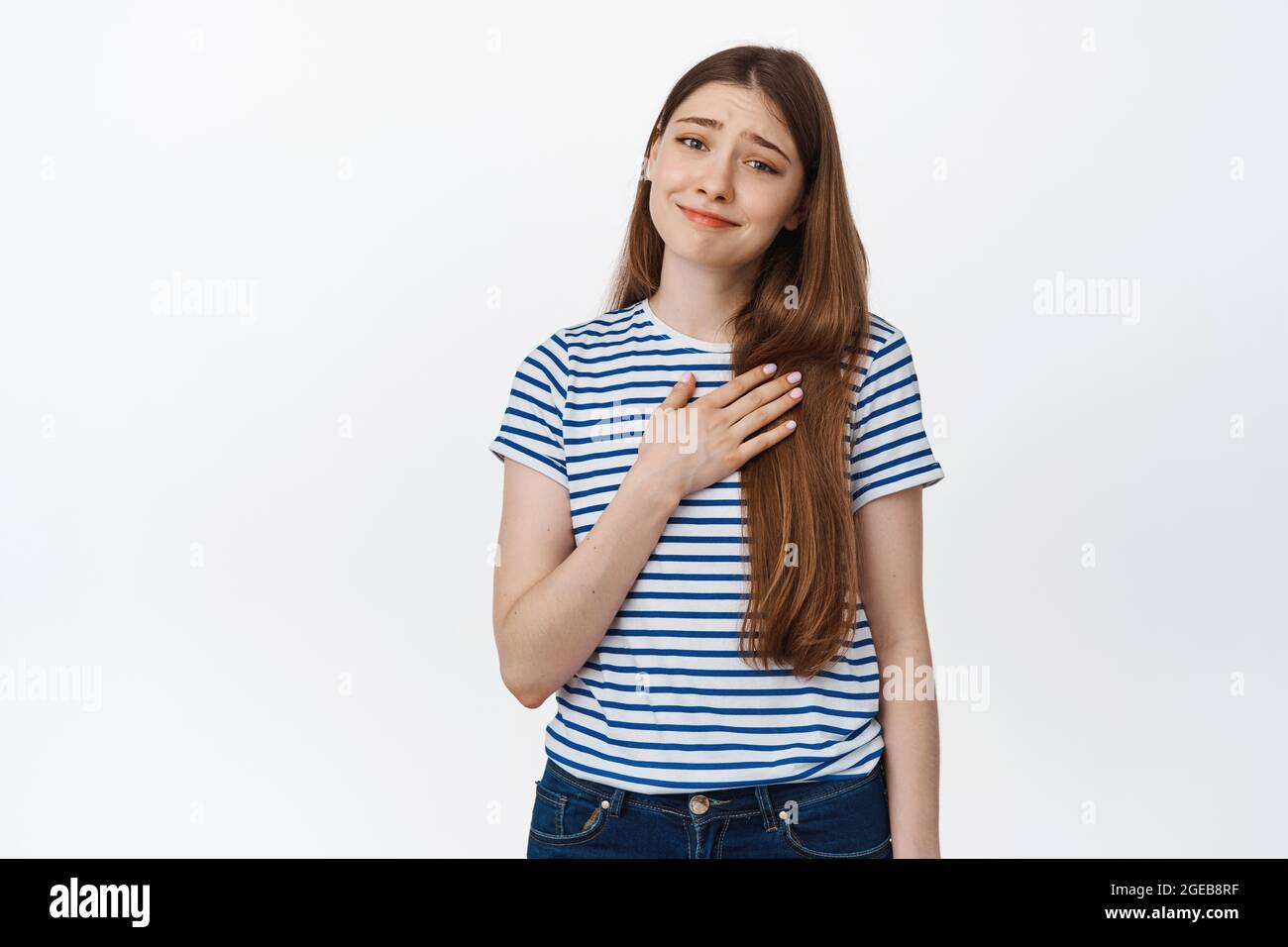 Image of flattered young woman hold hands on heart and looking thankful ...