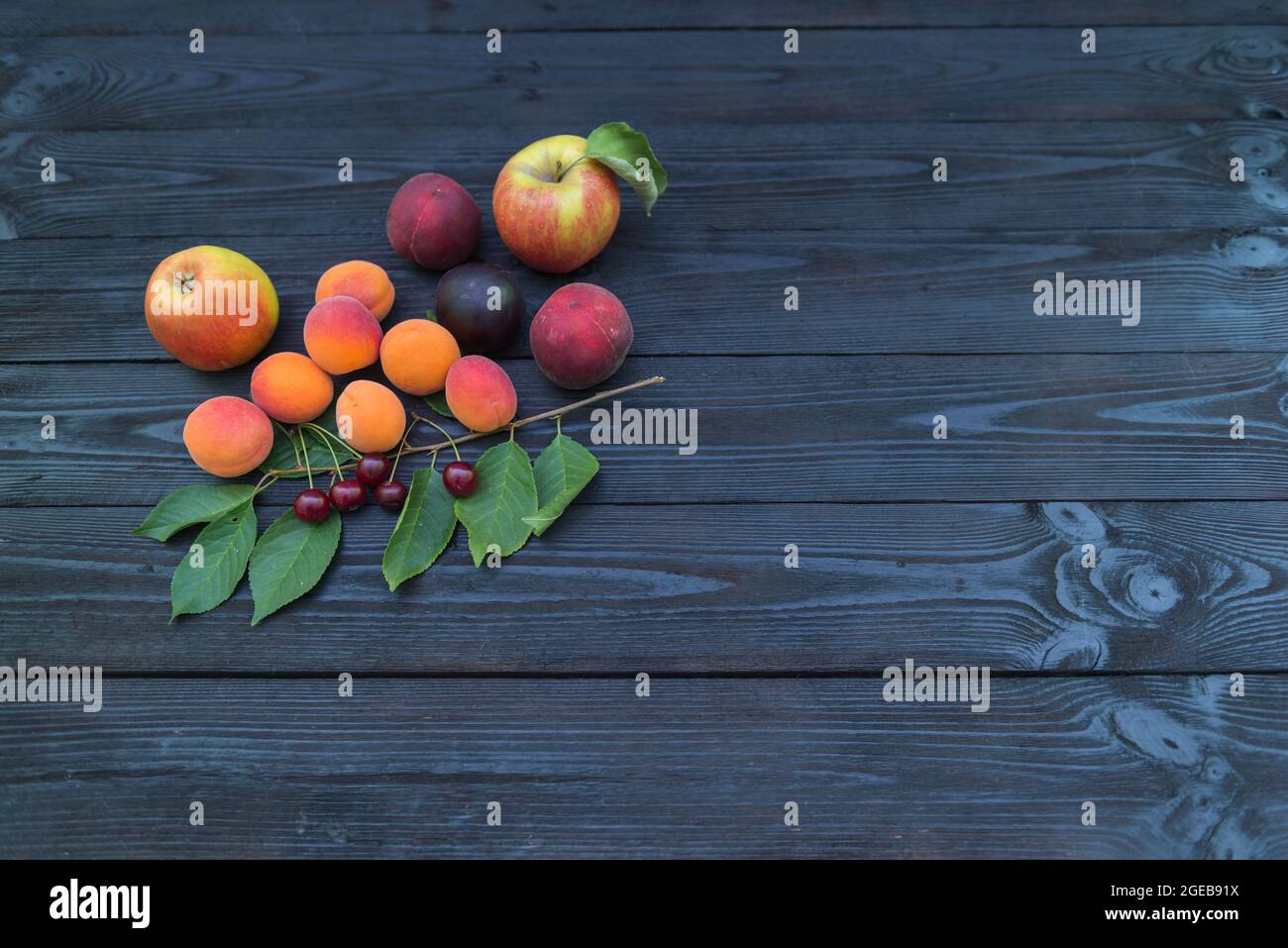 A set of various fruits arranged on a base of black boards. There is a ...