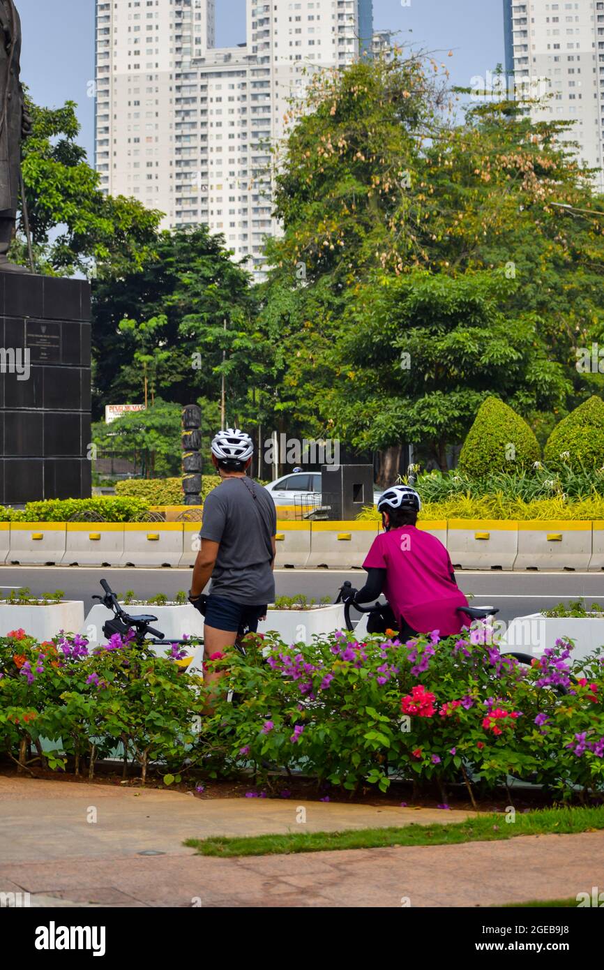 Two cyclists wearing safety helmets down a country lane stopping to ...