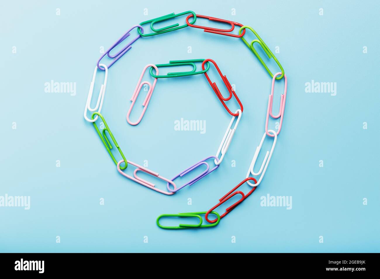 A chain of multi-colored paper clips on a blue background. Business ...