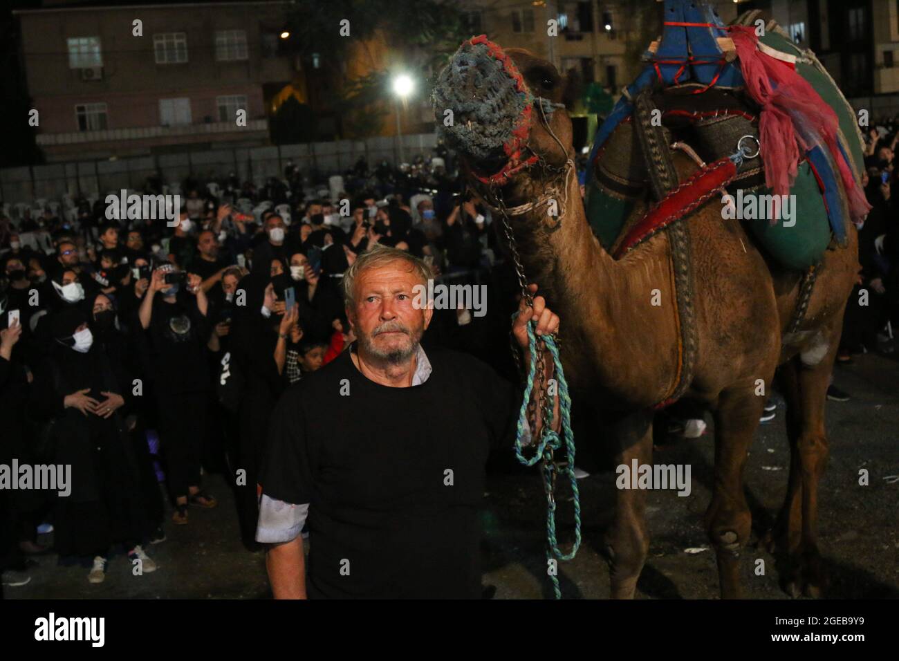 A man attends a mourning ceremony with a camel to commemorate martyrdom ...