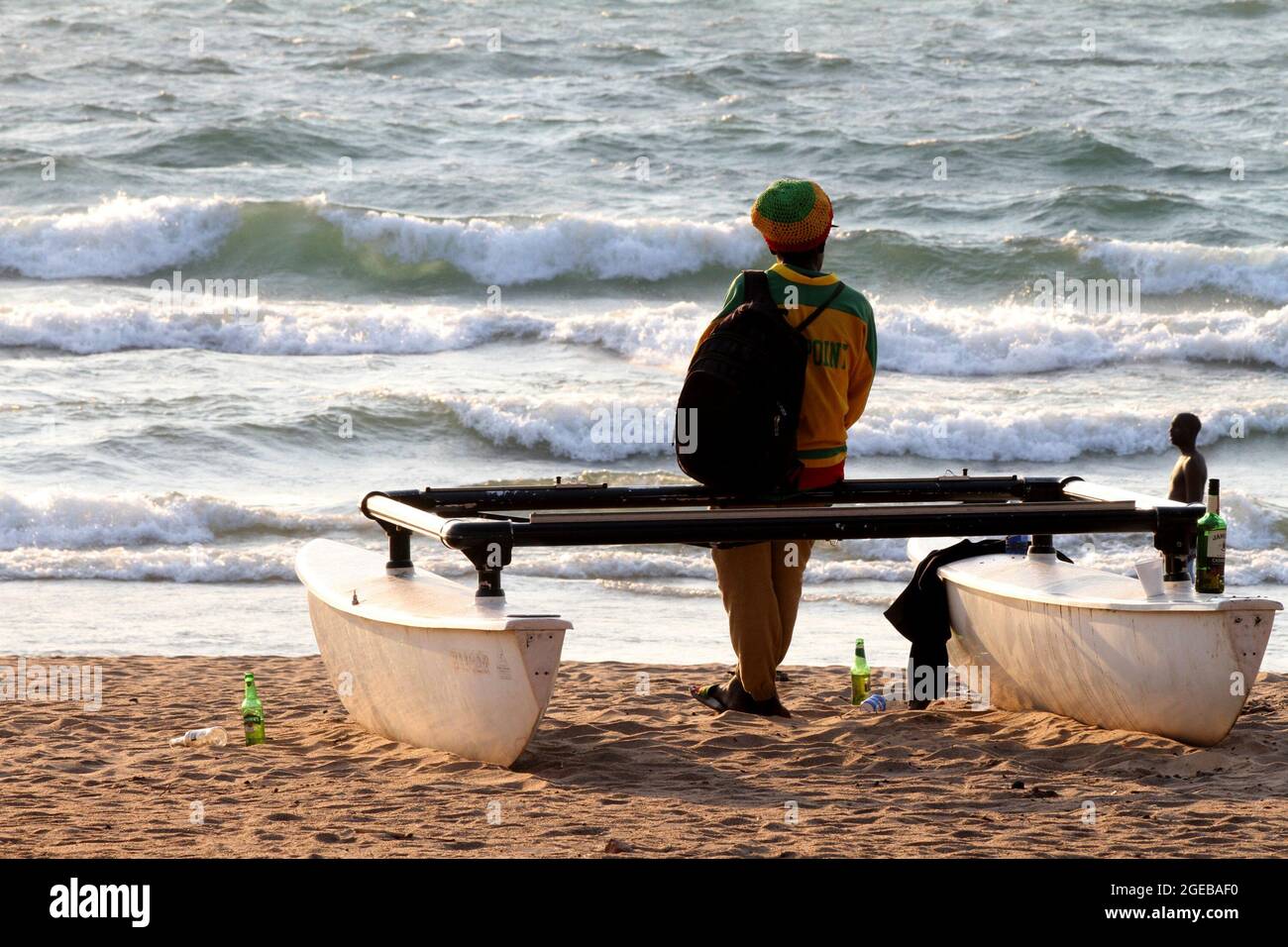 A man sits on a boat while looking at the lake early morning during a ...