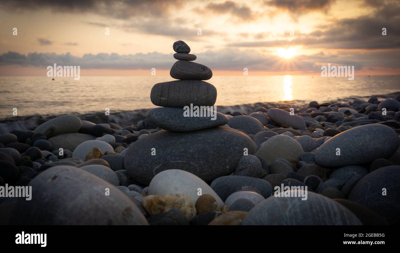 Stack of gray zen stones on the beach at sunset, beautiful seascape ...