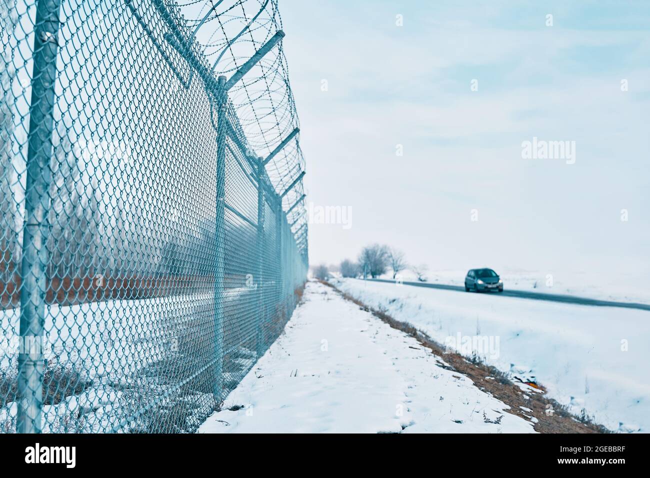 Private secured object near highway. Barbed wire fence on border in ...